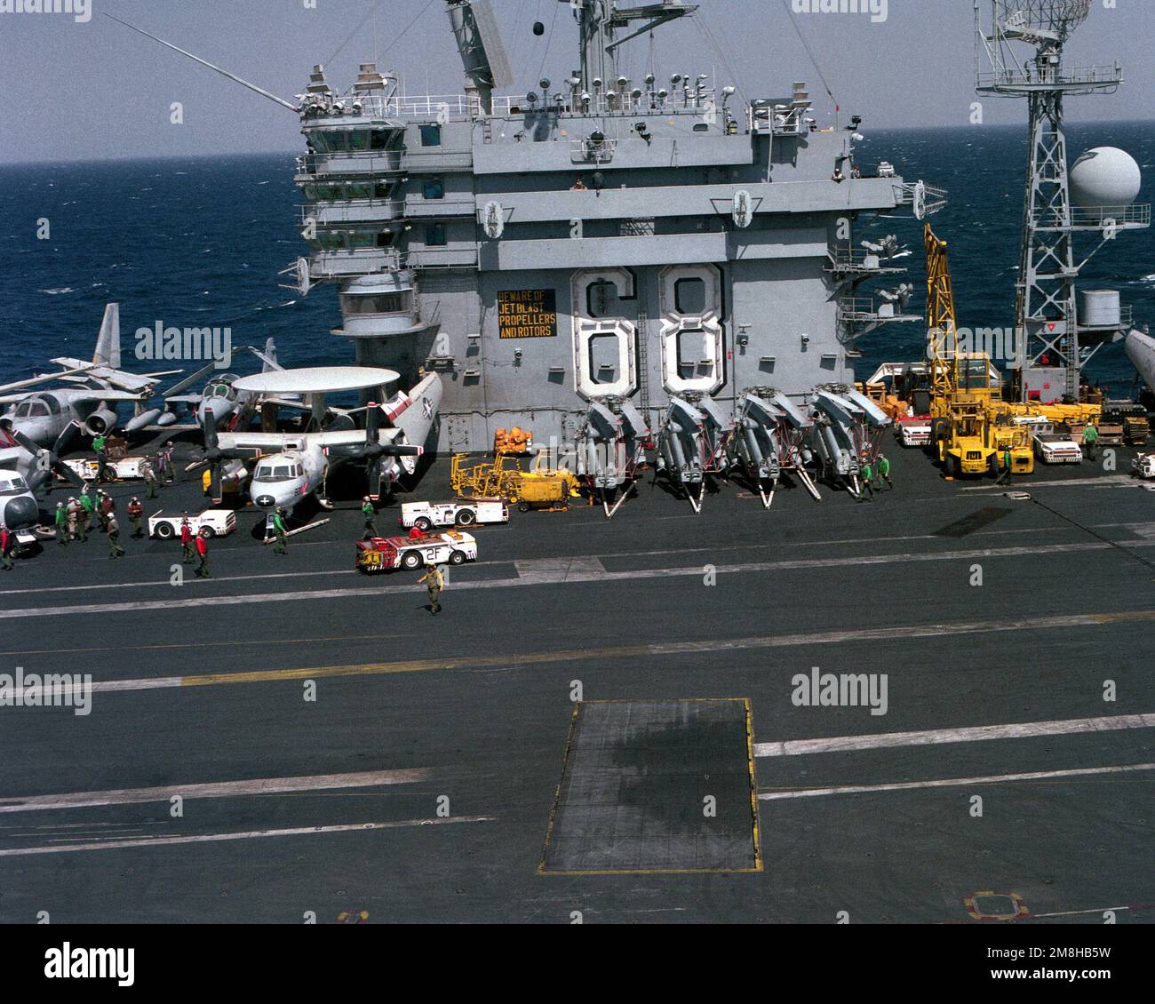 A view of various aircraft parked on the flight deck near the island of ...