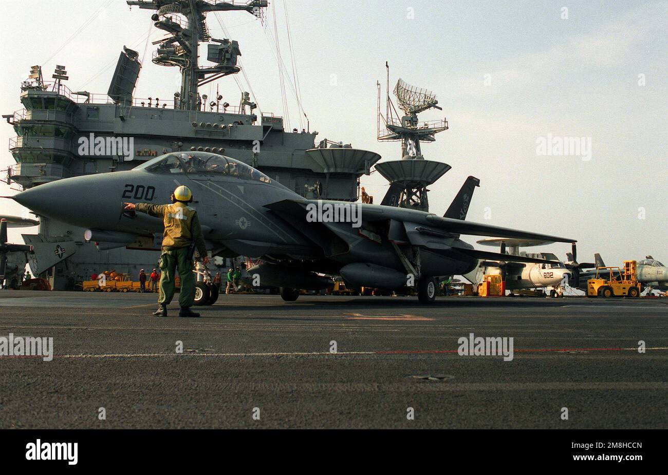 A plane director guides a Fighter Squadron 84 (VF-84) F-14A Tomcat ...