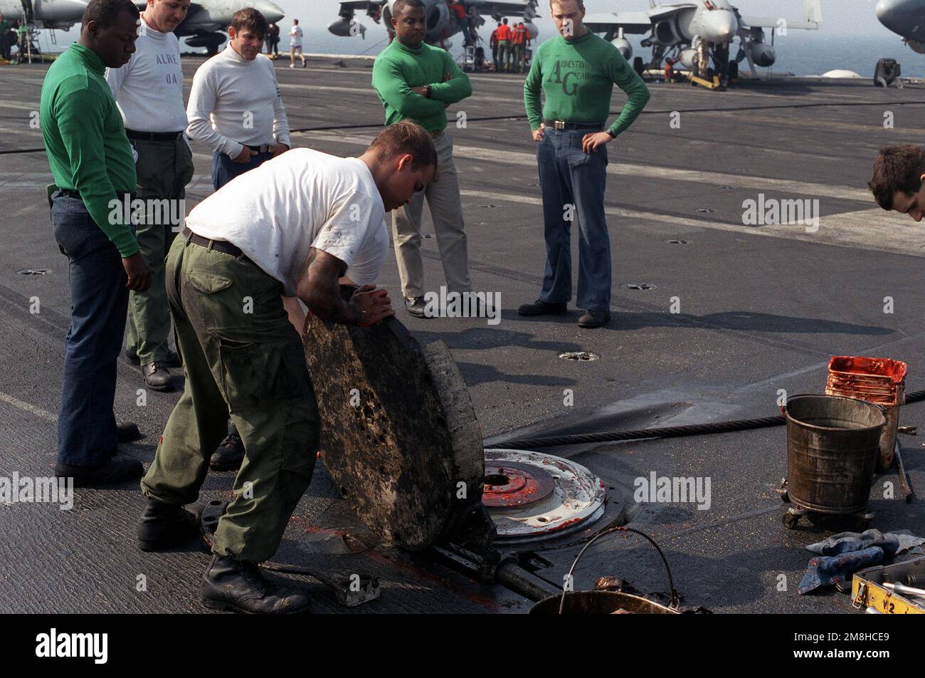 Aviation boatswain's mates service one of the retractable deck sheaves ...