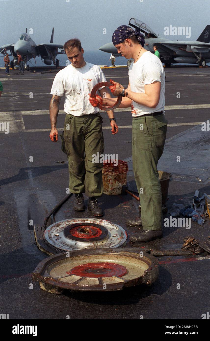 Aviation boatswain's mates service one of the retractable deck sheaves ...