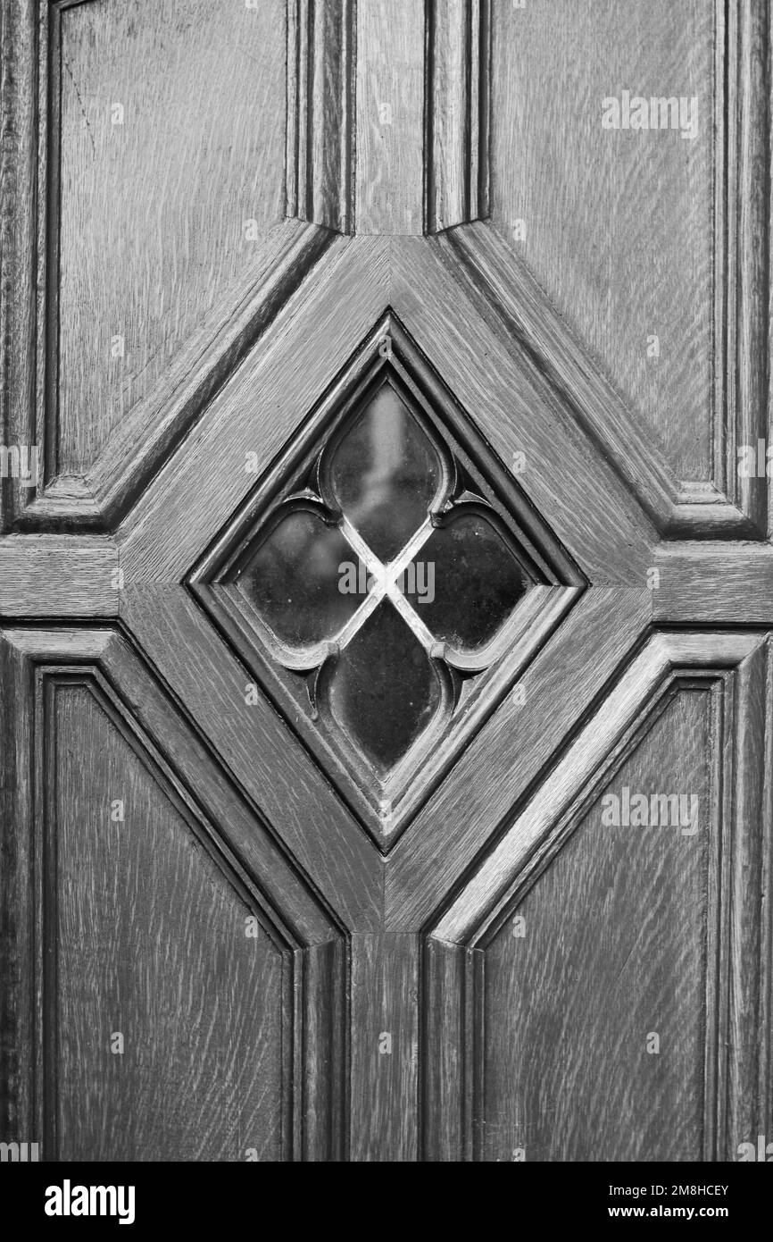 Vintage carved wood door with a diamond window in a black and white ...