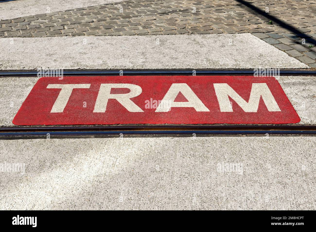 Warning sign for pedestrians crossing a road with railway tracks for a ...