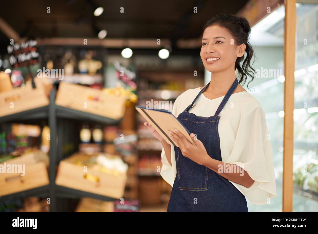 Portrait of positive grocery store worker with digital tablet Stock ...