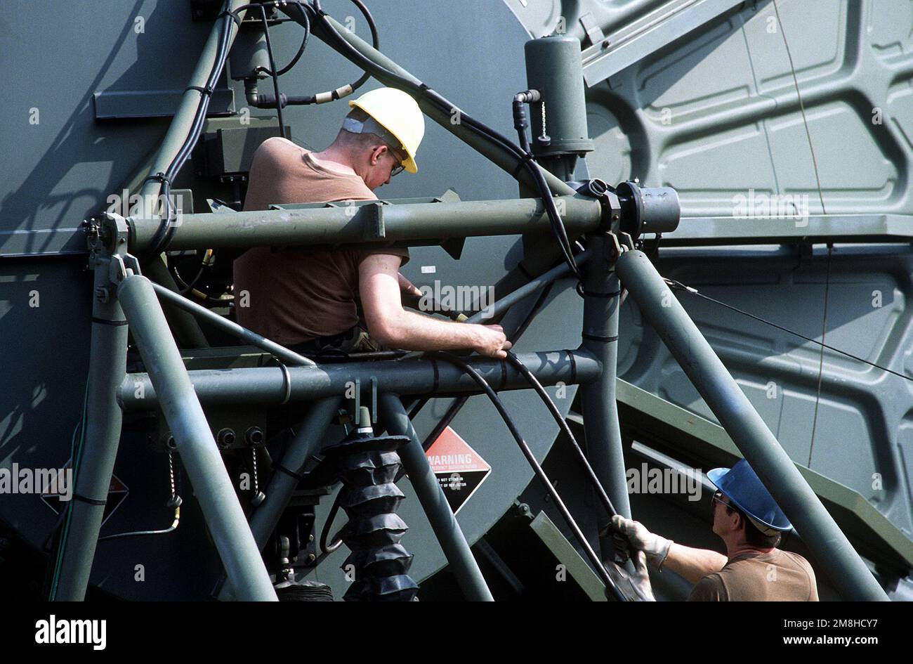 STAFF SGT. Kurt Brown and STAFF SGT. Robert Denbow attach cables to a ...