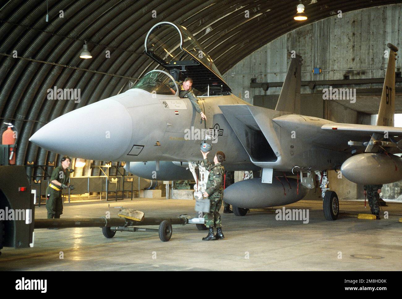 Ground crew members assist the pilot of an F-15C Eagle aircraft of the ...
