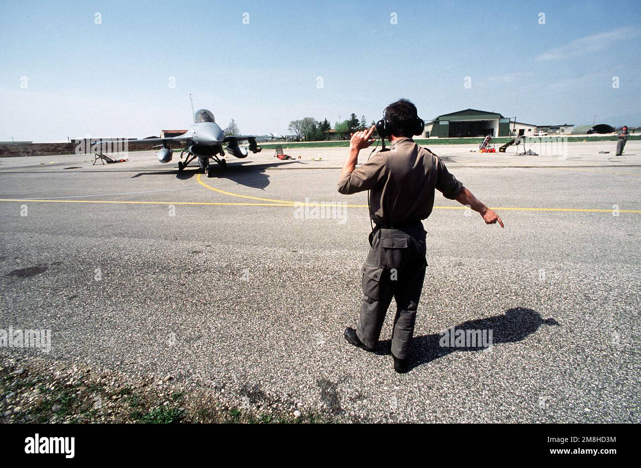 A ground crew member of the Dutch air force signals to the pilot of an ...