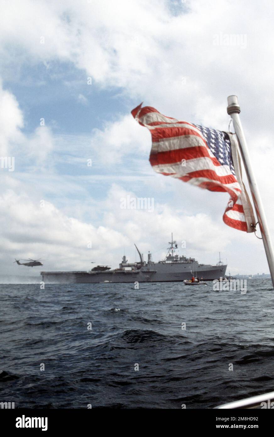 The national ensign frames the amphibious transport dock USS DULUTH ...