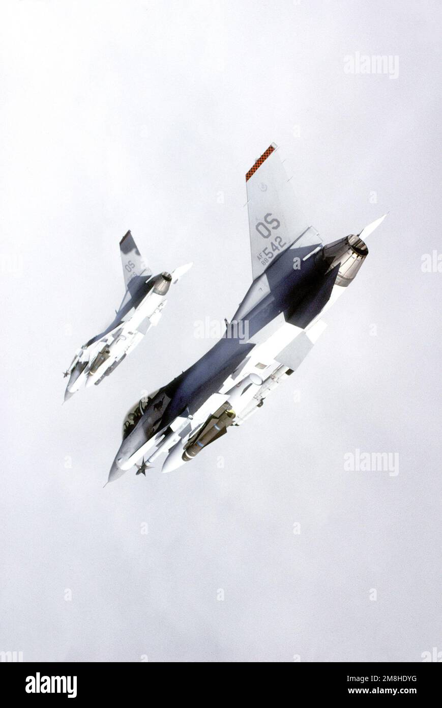 An air-to-air underside view of two F-16 Fighting Falcons from the 51st ...