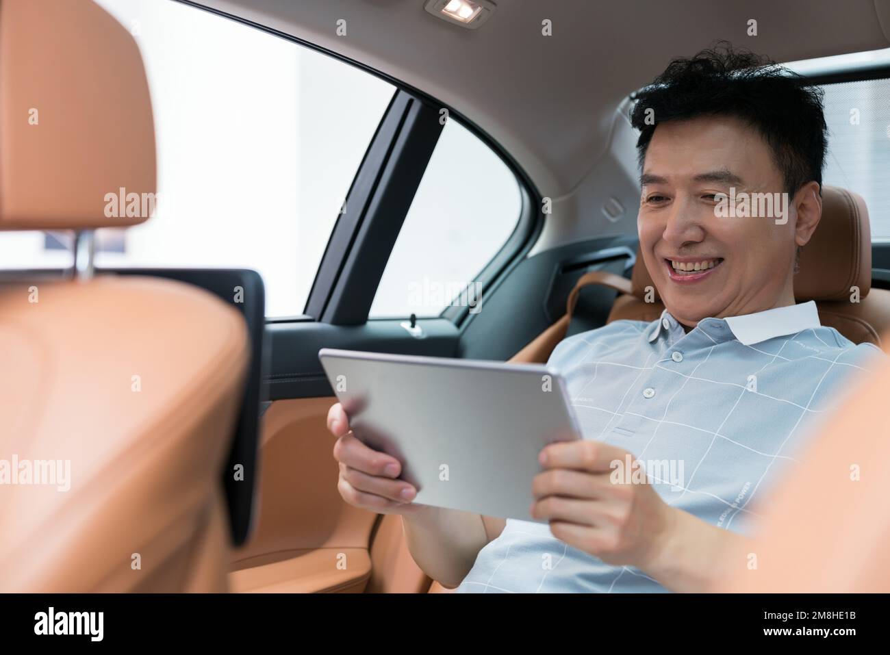 Business man in the car to use tablet Stock Photo - Alamy
