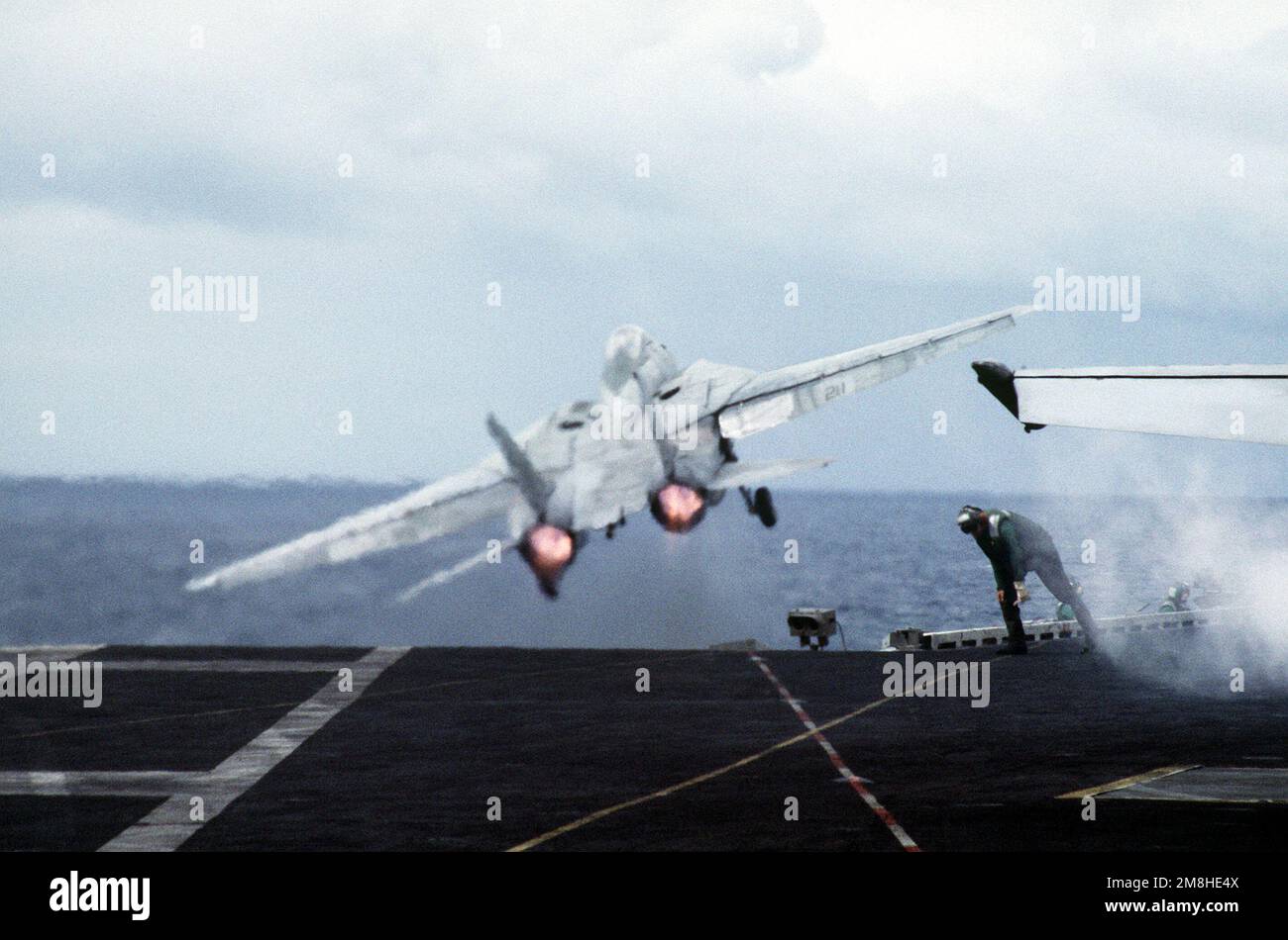 An F-14A Tomcat aircraft banks to the left after being launched from ...