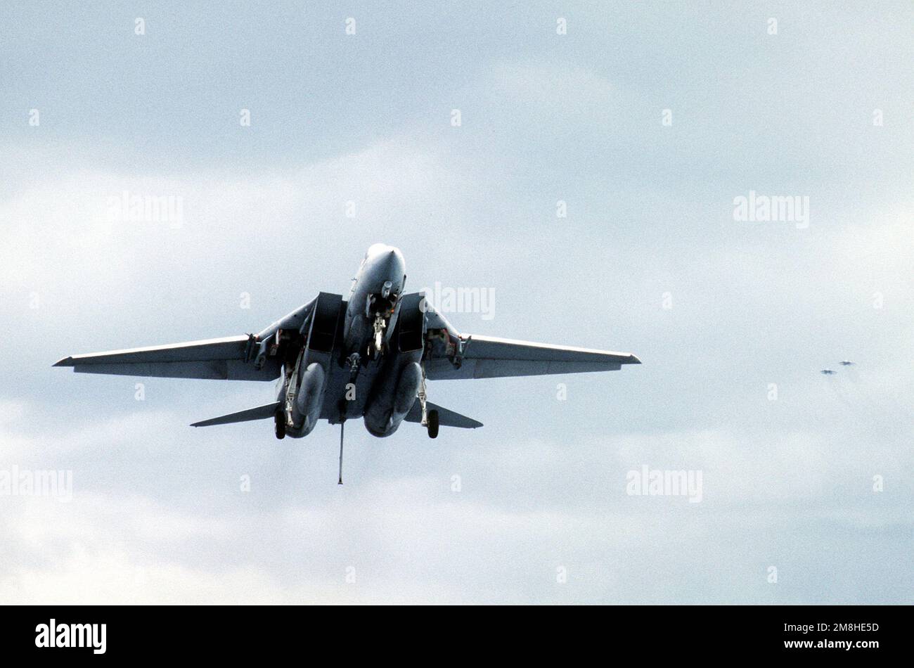 With its landing gear and tailhook lowered, an F-14A Tomcat aircraft ...