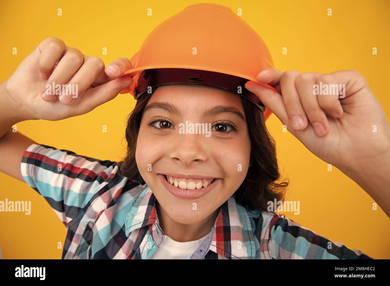 Close up portrait of child builder in helmet. Teenage girl on repairing ...