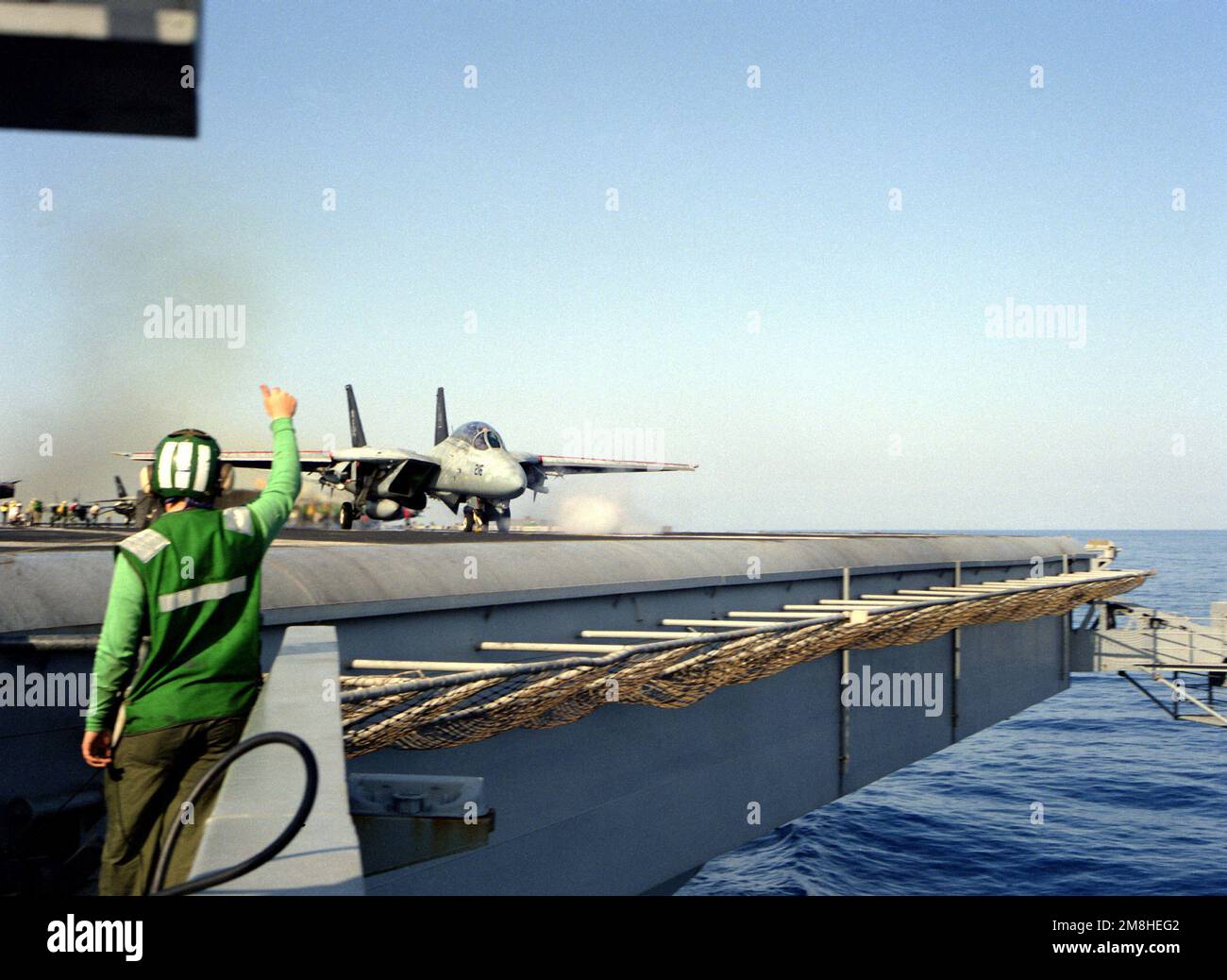 The waist catapult safety officer gives the "thumbs-up" signal as a ...