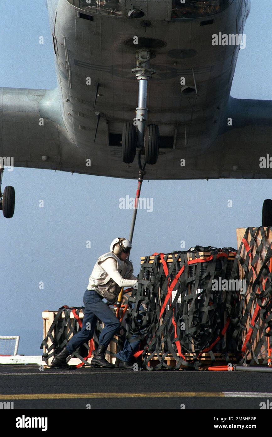 A flight deck crewman releases the cargo sling as a CH-46 Sea Knight ...