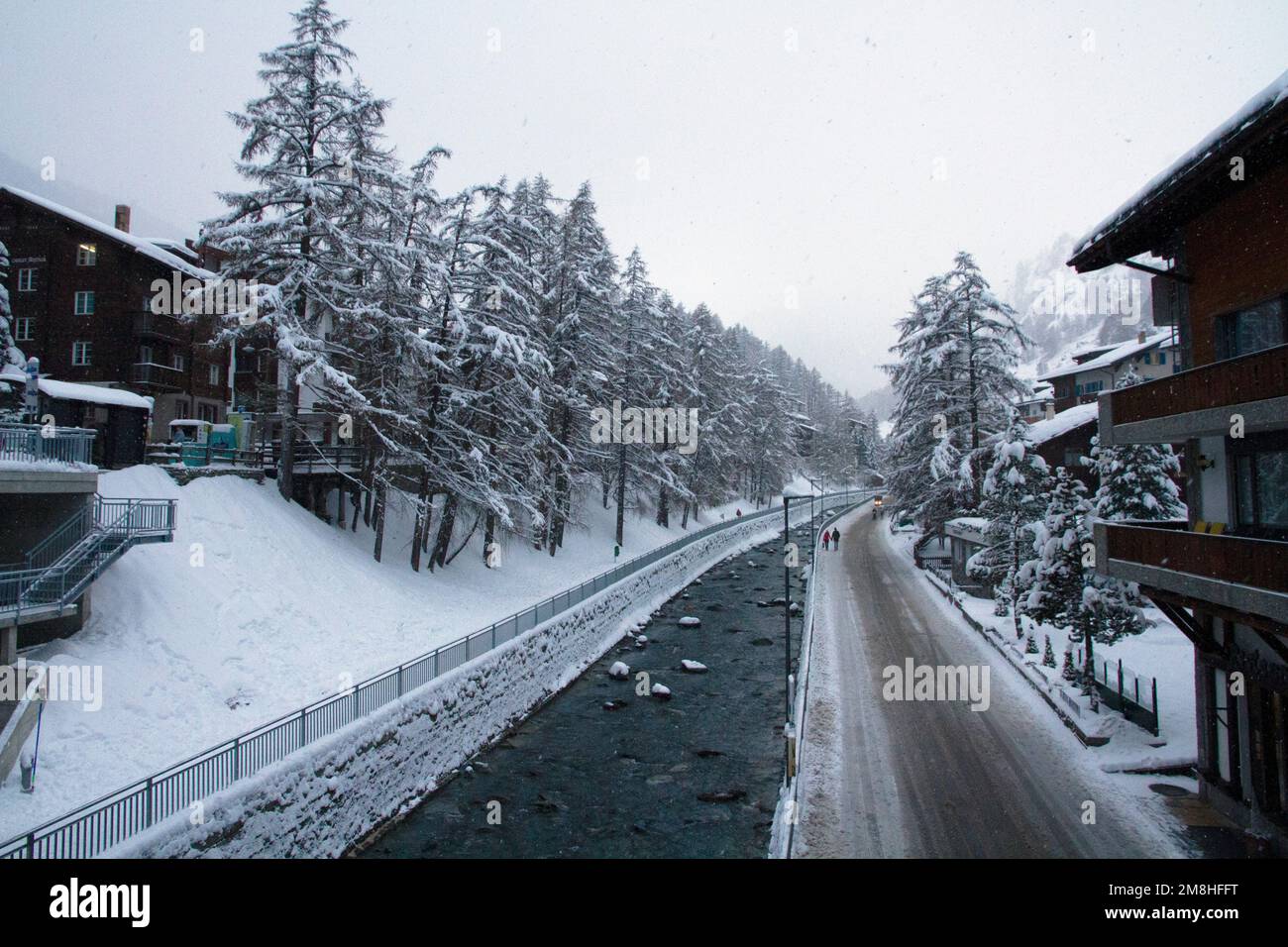 A beautiful winter scene with a frozen river surrounded by snow-covered ...