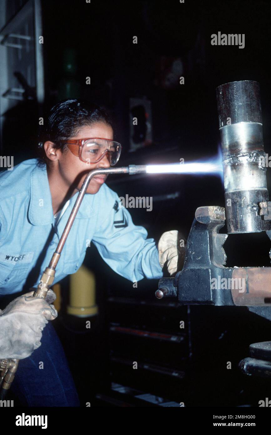 Hull Technician 2nd Class Ianthia Wycoff preheats a pipe with a rosebud ...
