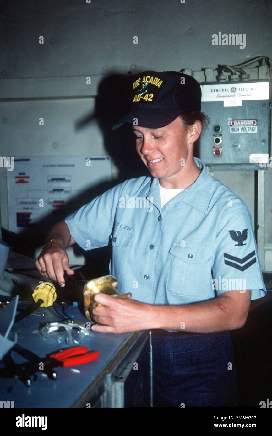 Electrician's Mate 2nd Class Lisa Smith checks a power receptacle ...