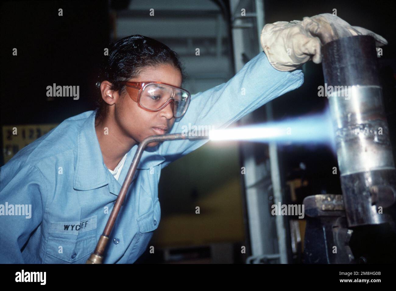 Hull Technician 2nd Class Ianthia Wycoff preheats a pipe with a rosebud ...