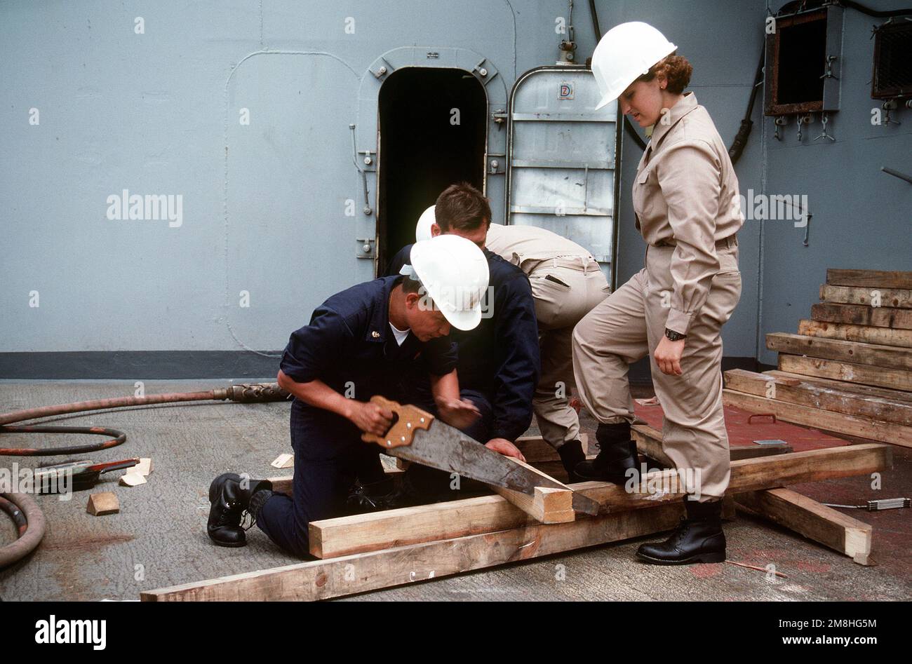 ENSIGN Robin Roch assists as other members of a damage control team cut ...