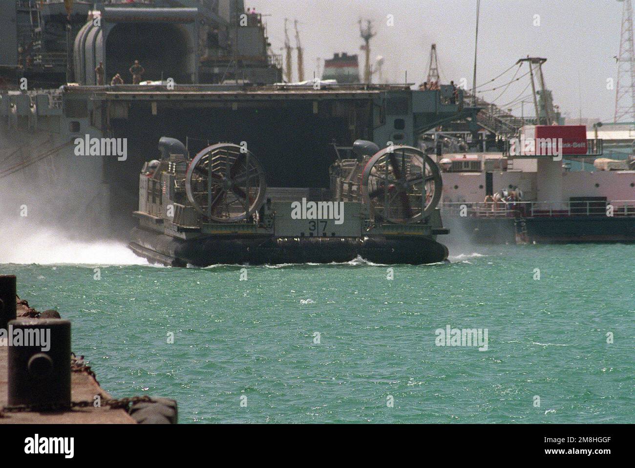 An air-cushioned landing craft emerges from the well deck of the ...