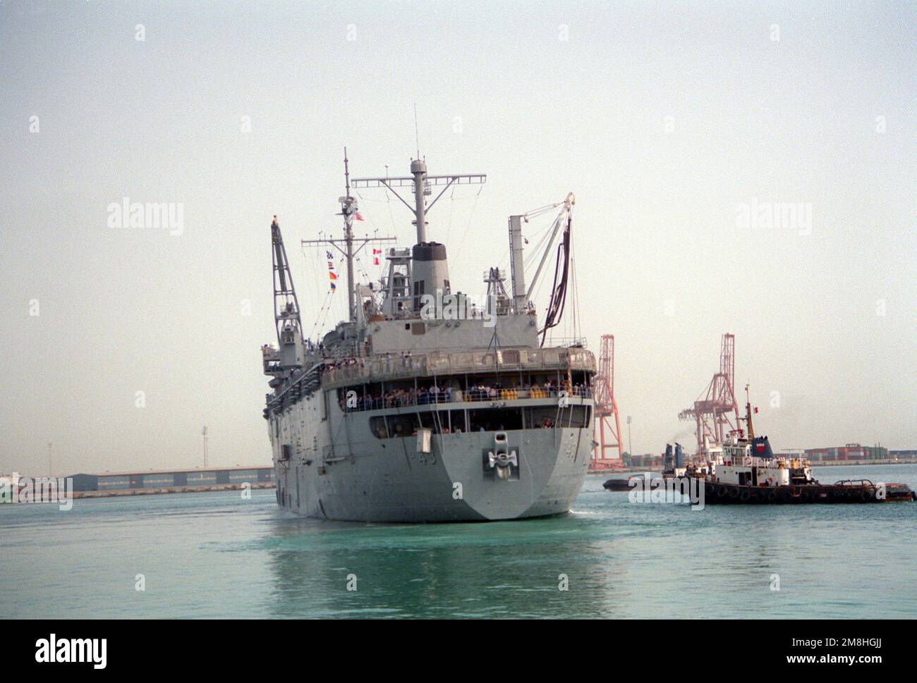 Tugs assist the destroyer tender USS CAPE COD (AD-43) into a berth at ...