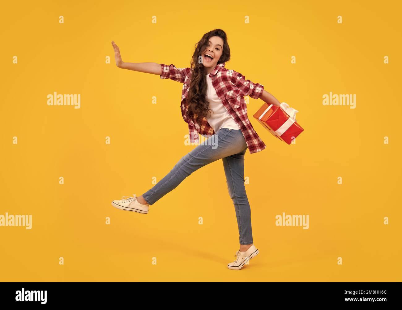 Amazed teenager. Child with gift present box on isolated studio ...