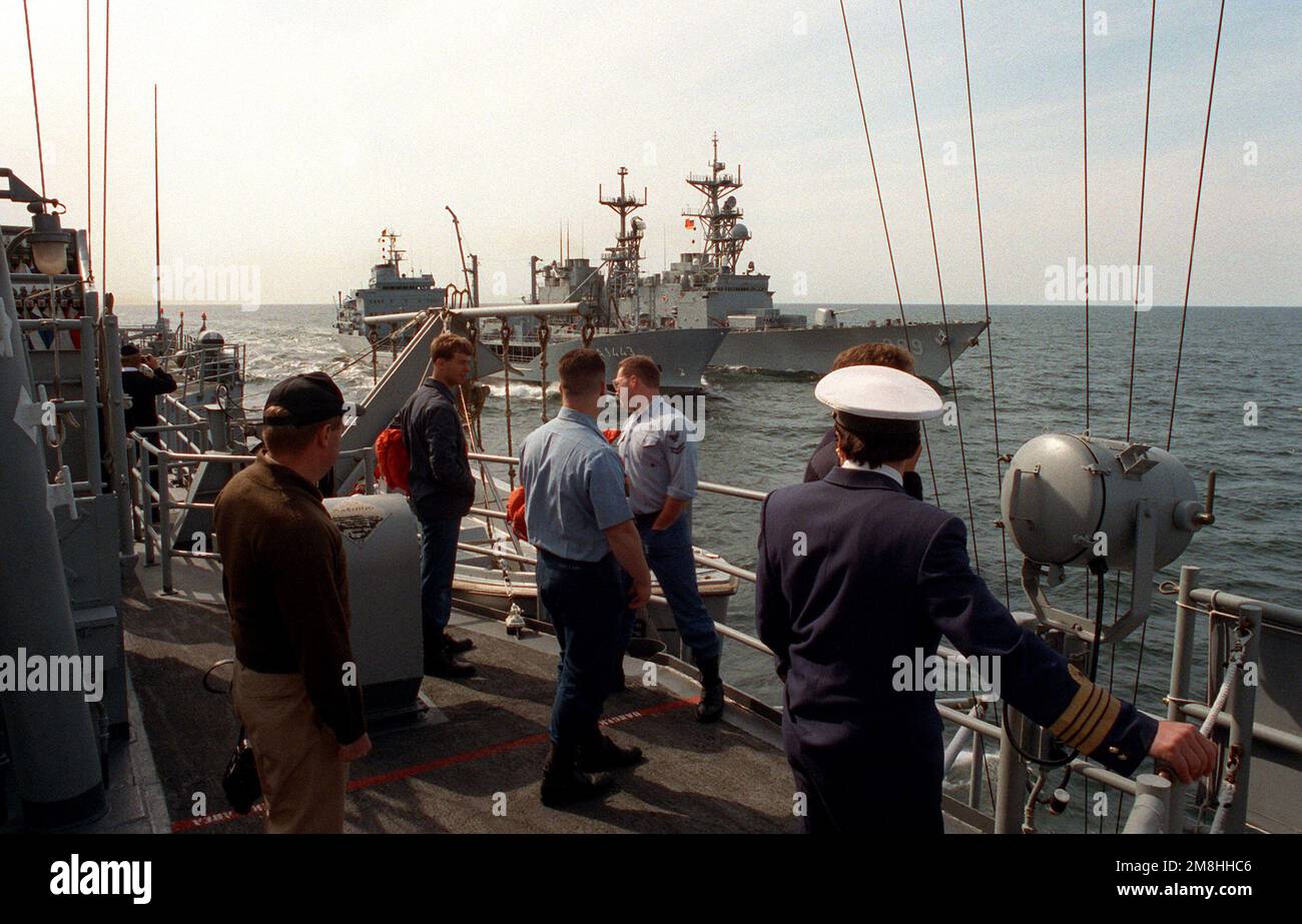 A foreign naval officer observes from the rail of the guided missile ...