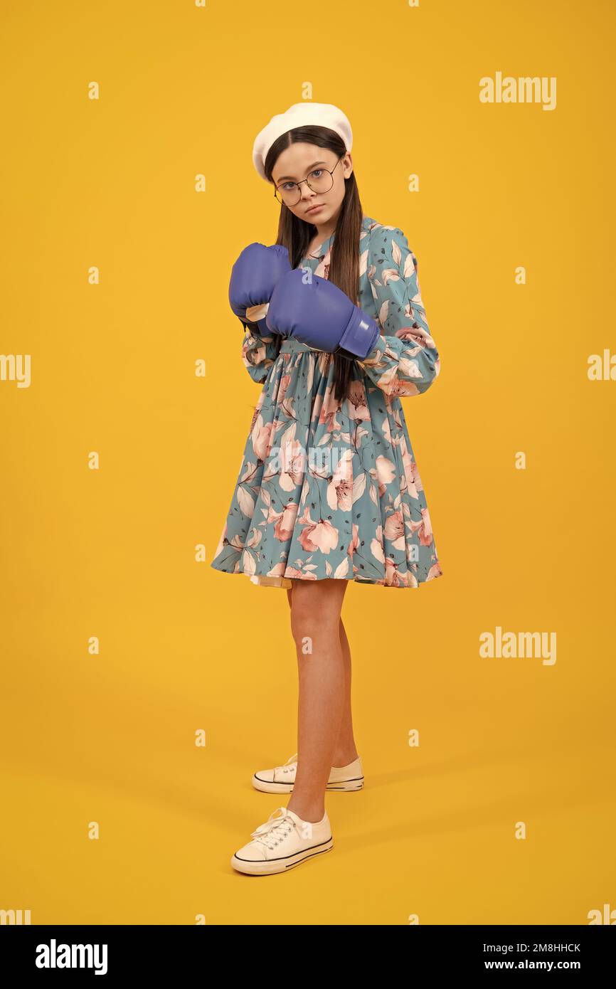 Teenage fun boxer girl in boxing gloves on yellow isolated background ...