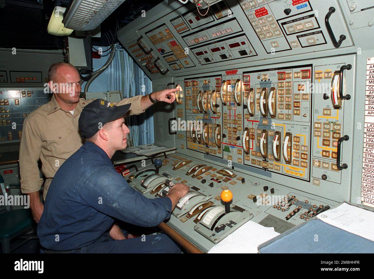 Crewmen monitor a control panel in an engineering space aboard the ...
