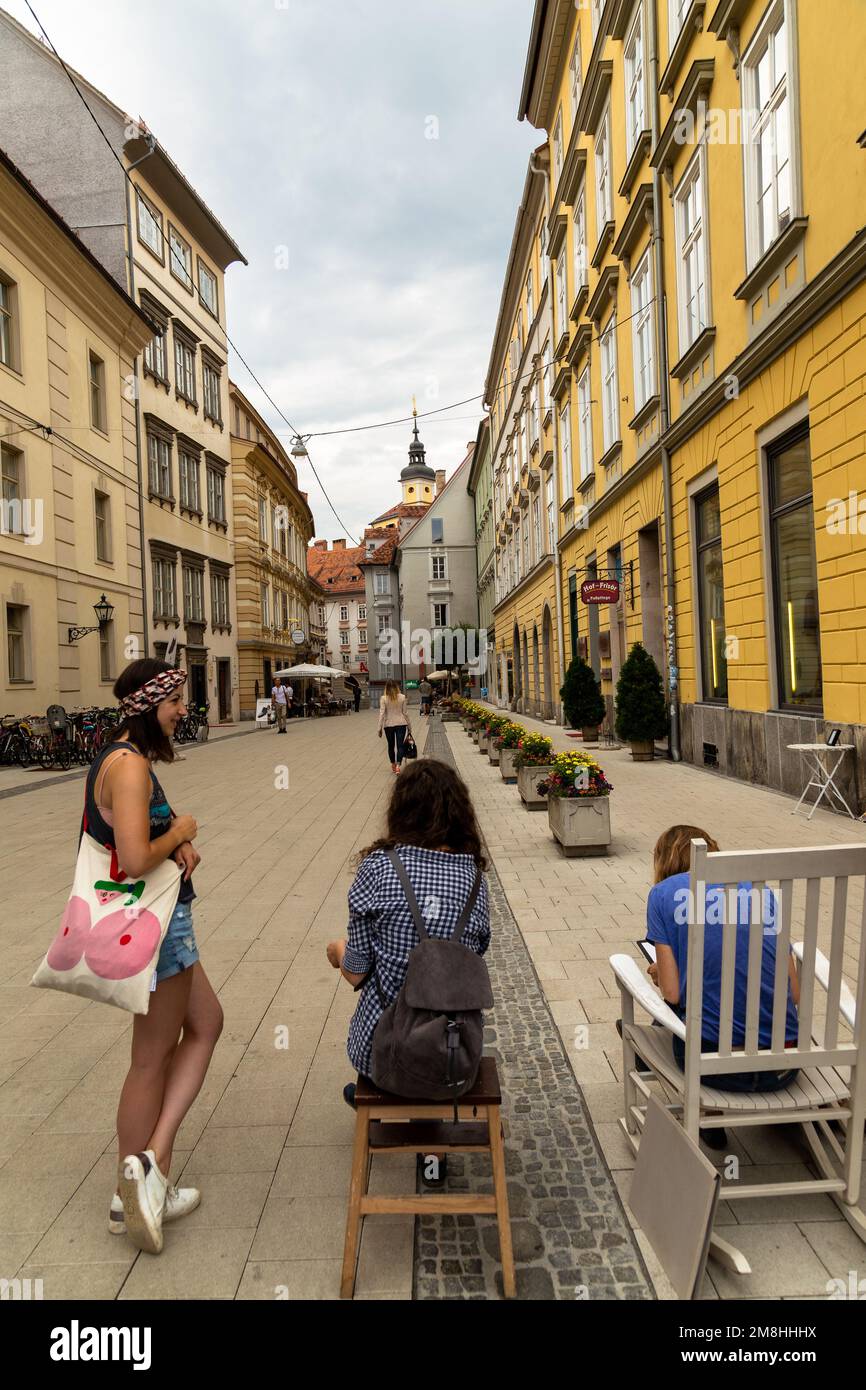 People sitting on steps and benches in and around Graz, Styria, Austria ...