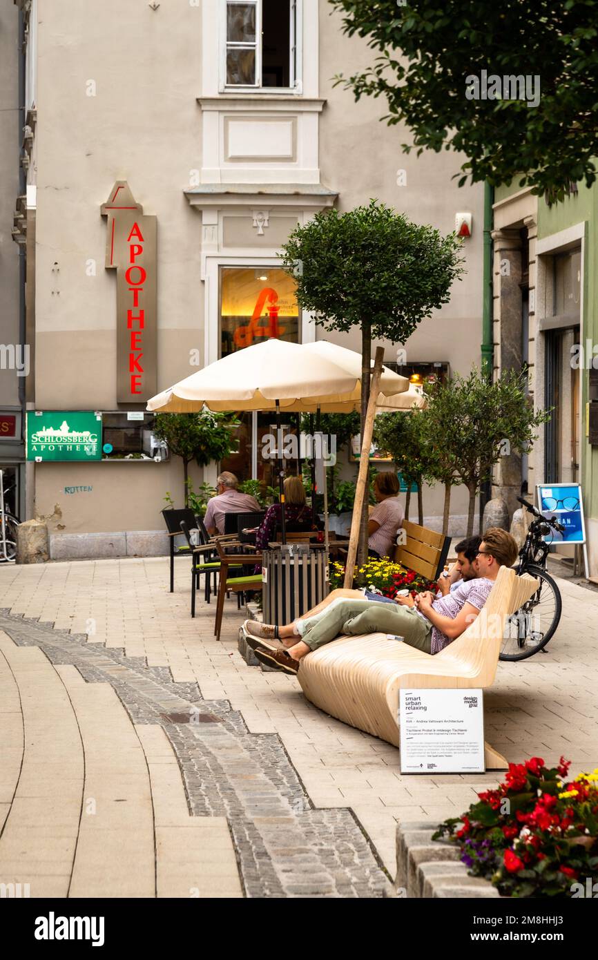 People sitting on steps and benches in and around Graz, Styria, Austria ...