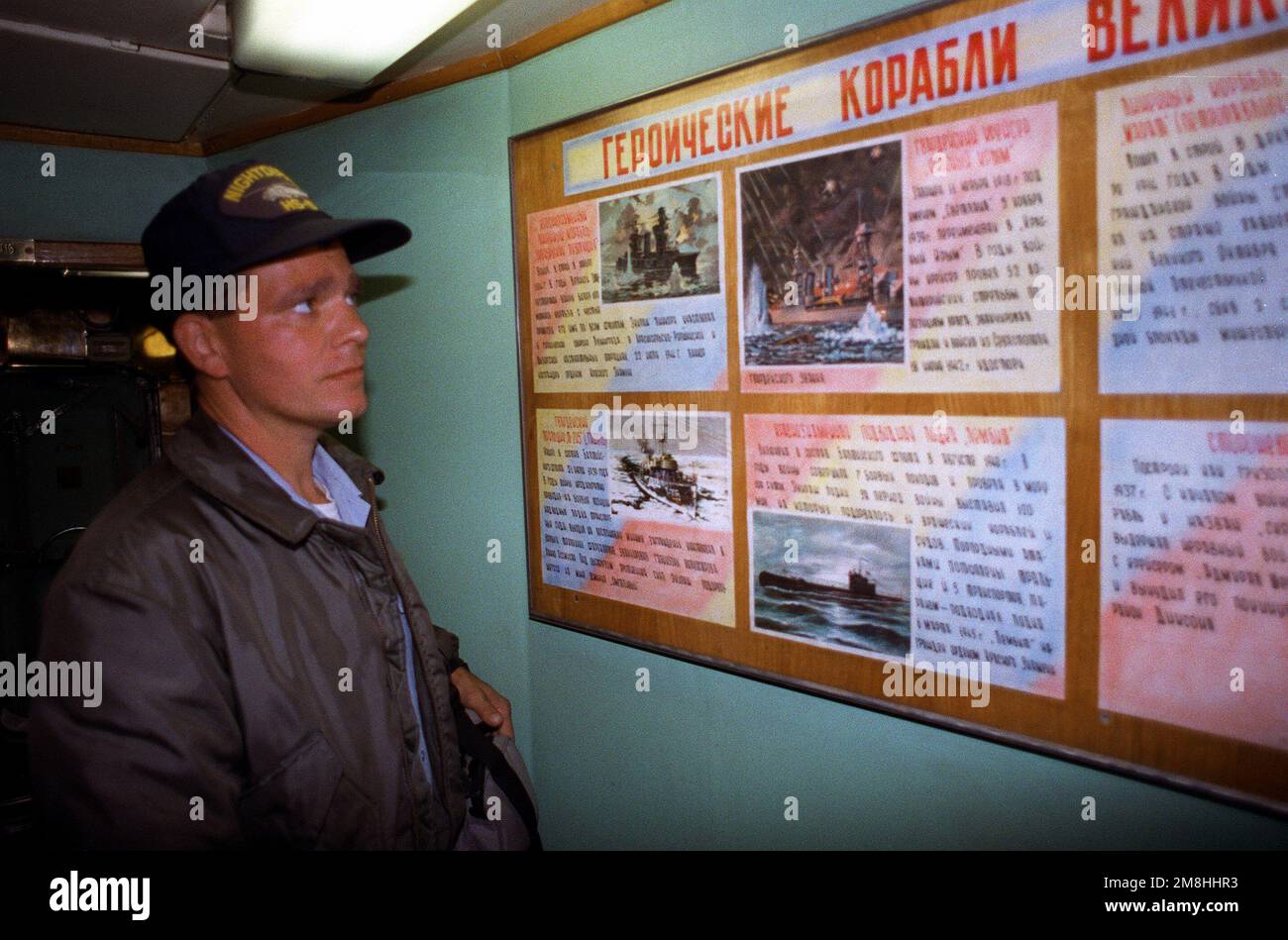 A crewman from the destroyer USS DEYO (DD-989) examines a bulletin ...