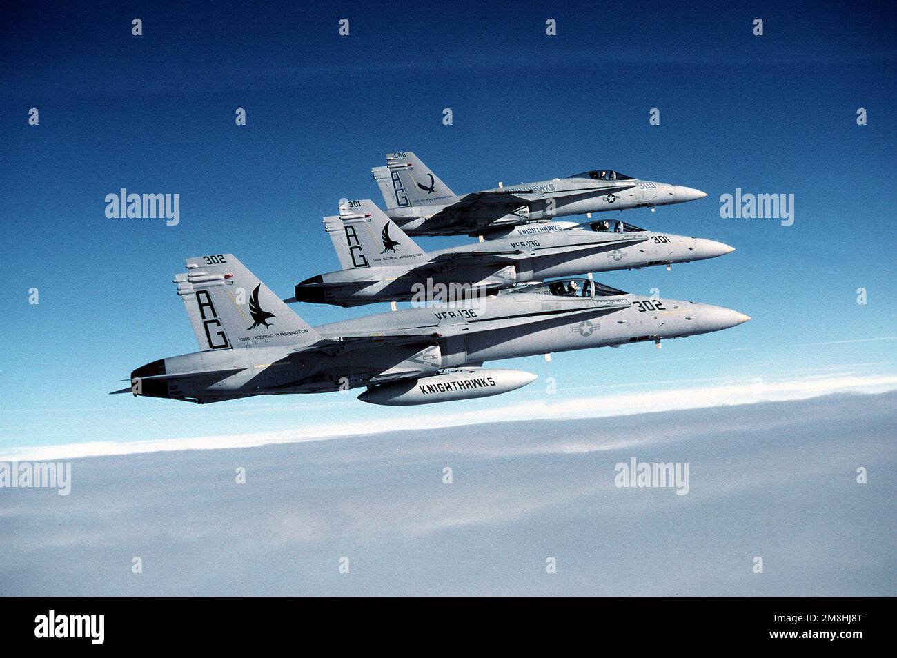 An air-to-air right side view of three Fighter Attack Squadron 136 (VFA ...