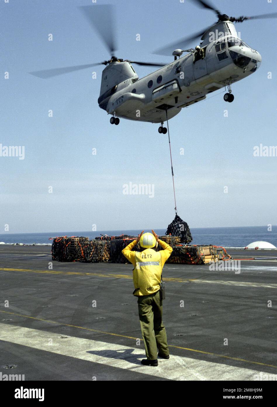A plane director signals to the pilot of an HH-46D Sea Knight of ...