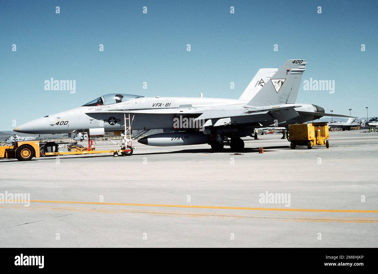 An MD-3A tow tractor is positioned in front of a Strike Fighter ...