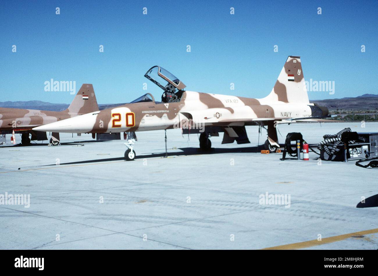 An F-5E Tiger II aircraft painted in camouflage paint scheme stands on ...