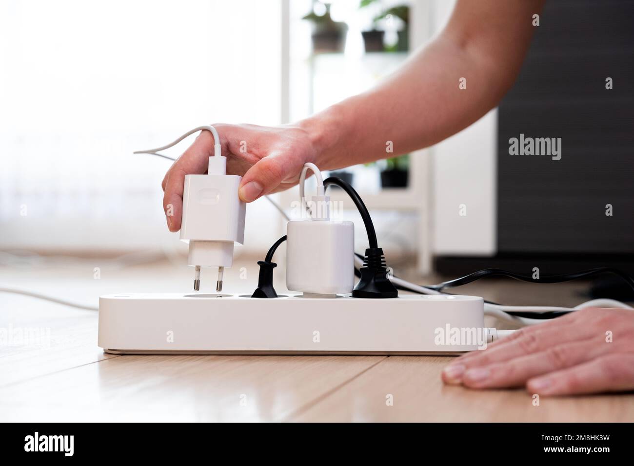 Man plugs in the electric charger. Energy savings, energy efficiency ...