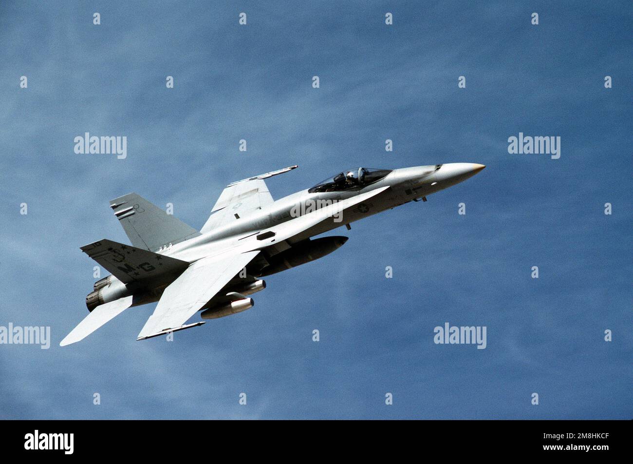 An in flight right front banking view of an F/A-18A Hornet aircraft of ...