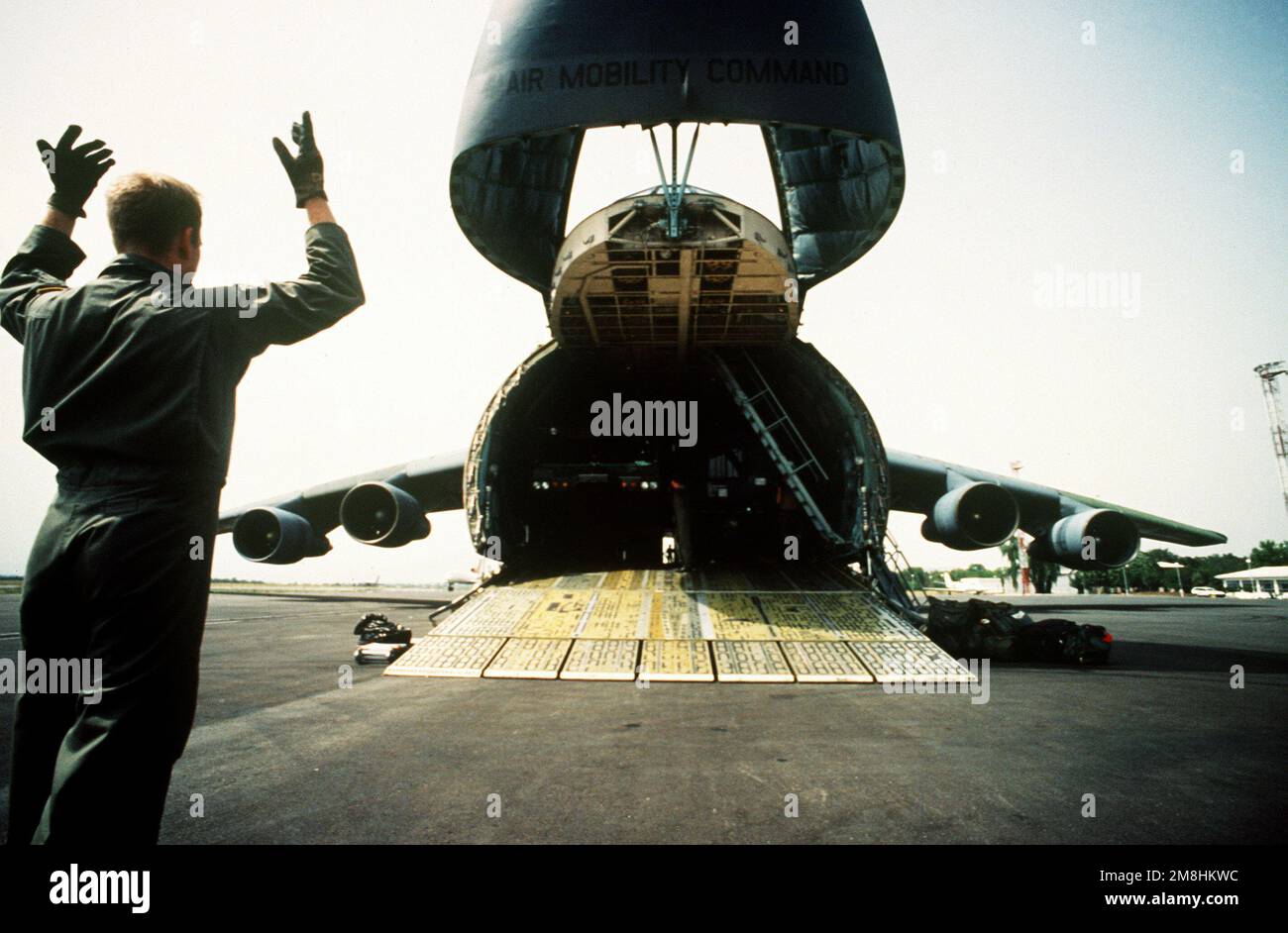 A C-5 Galaxy loadmaster directs off-loading vehicles and equipment from ...