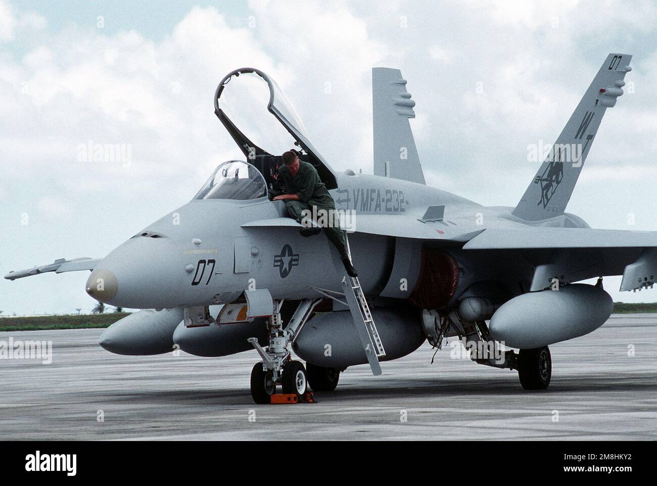 A ground crew member steps down from the cockpit of a Marine Fighter ...