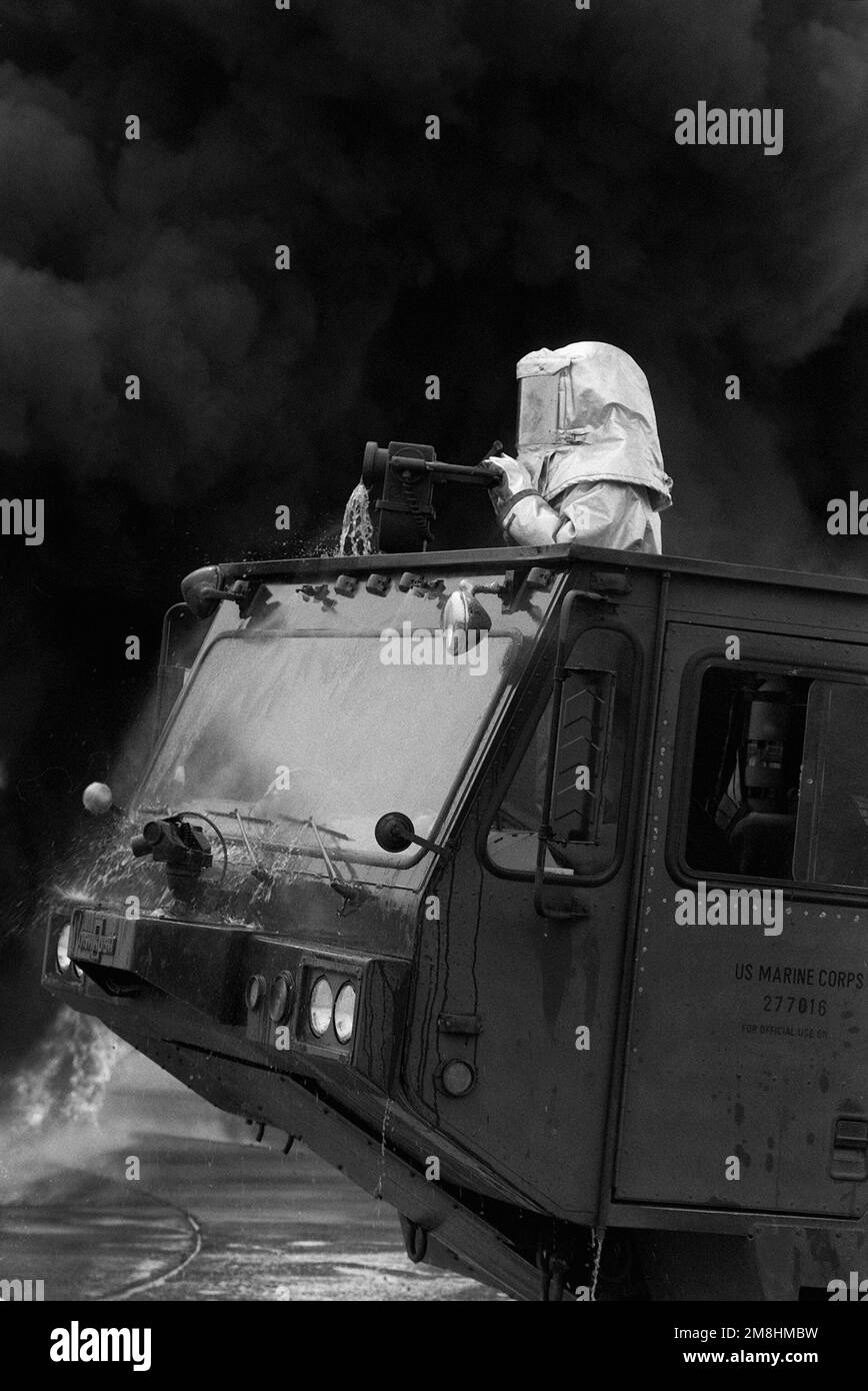 A fire and rescue Marine wears fire protective suit as he operates a ...