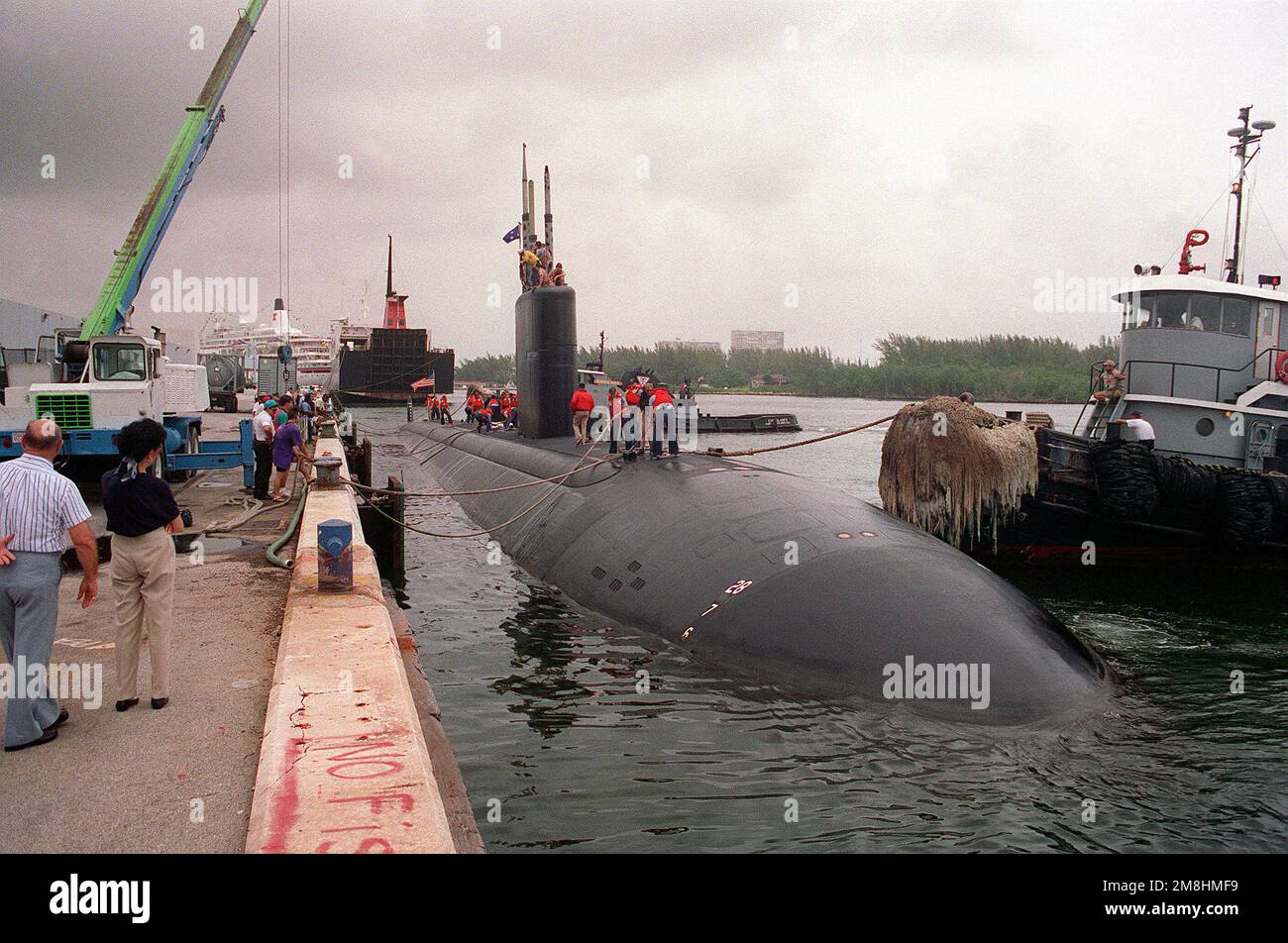 Tugs maneuver the nuclear-powered attack submarine USS MIAMI (SSN-755) into a berth. Base: Port ...