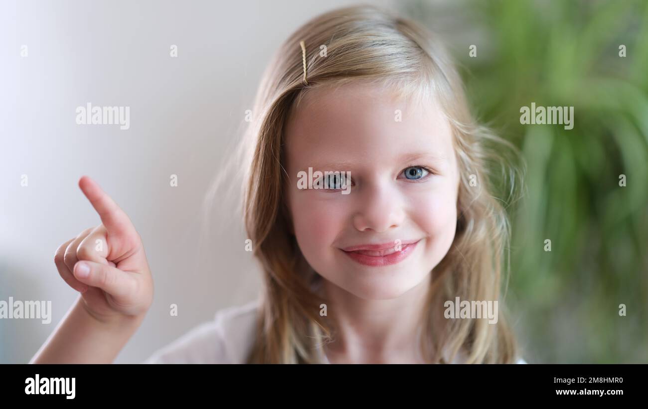 Portrait of cheerful smiling child girl points finger to side Stock ...