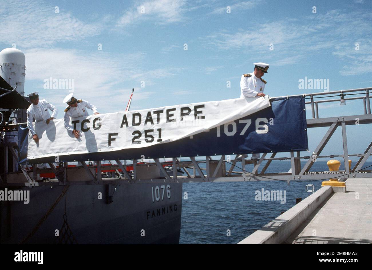 Crew members of the Turkish frigate TCG ADATEPE (F-251) cover the ship ...