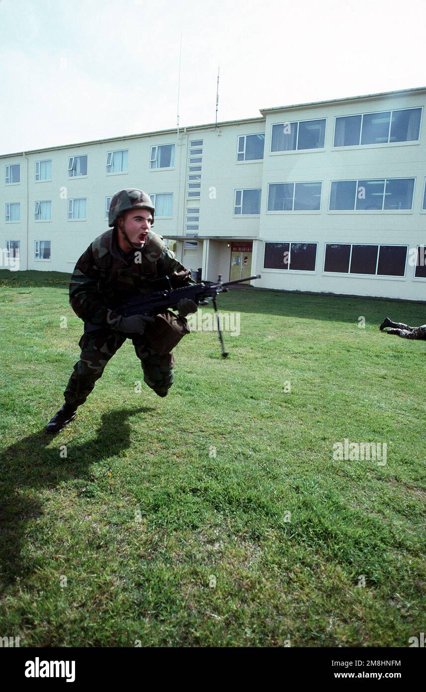 A member of the Marine Security Force charges forward with his M-249 ...