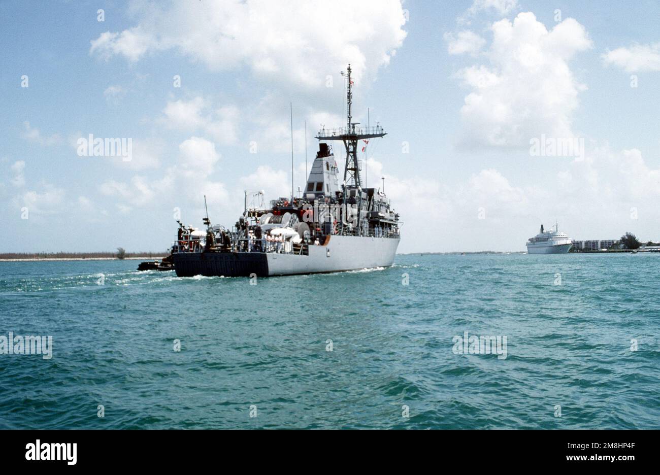 Crew members stand at the rail on the stern of the mine countermeasures ...