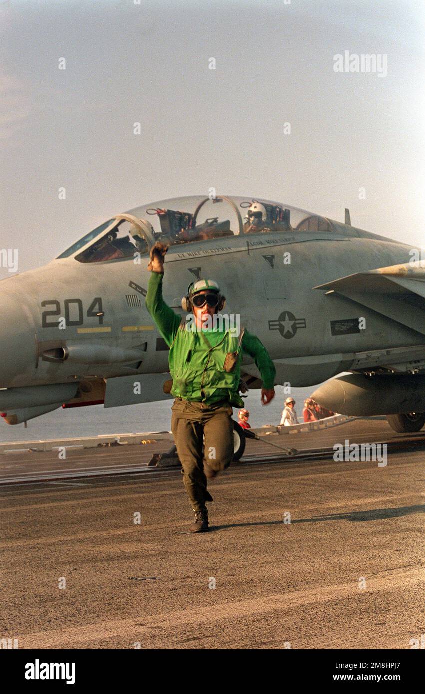 A catapult crewman clears the catapult for the launch of a Fighter Squadron 103 (VF-103) F-14B ...
