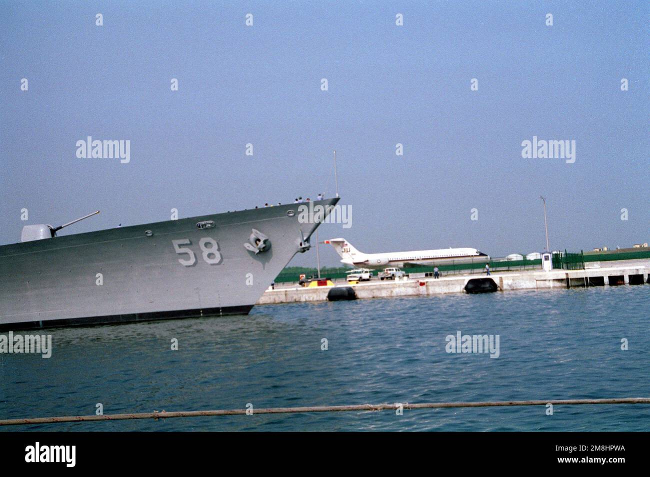 Crewmen prepare to raise the union jack on the bow of the guided ...