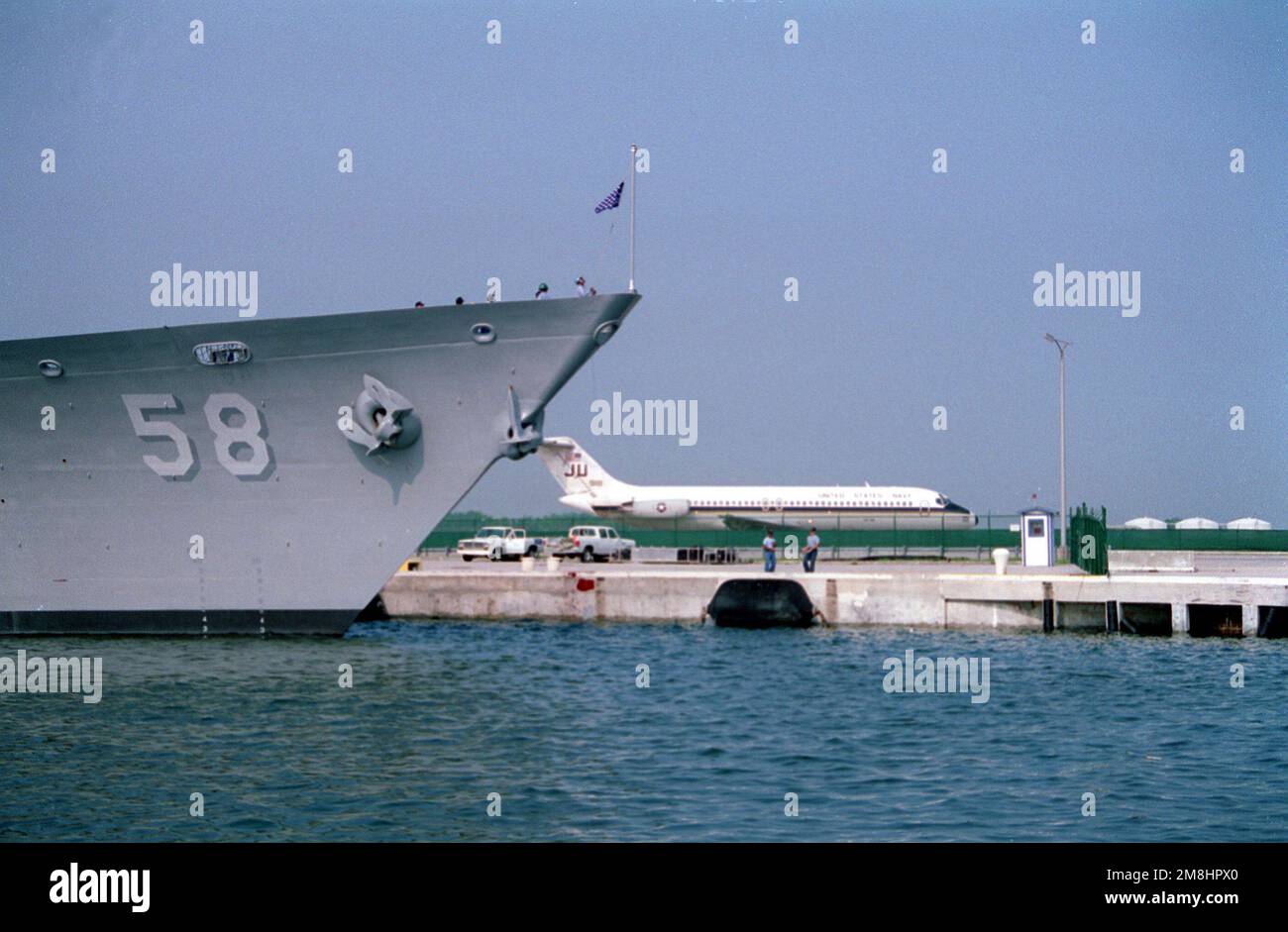 Crewmen raise the union jack on the bow of the guided missile cruiser ...