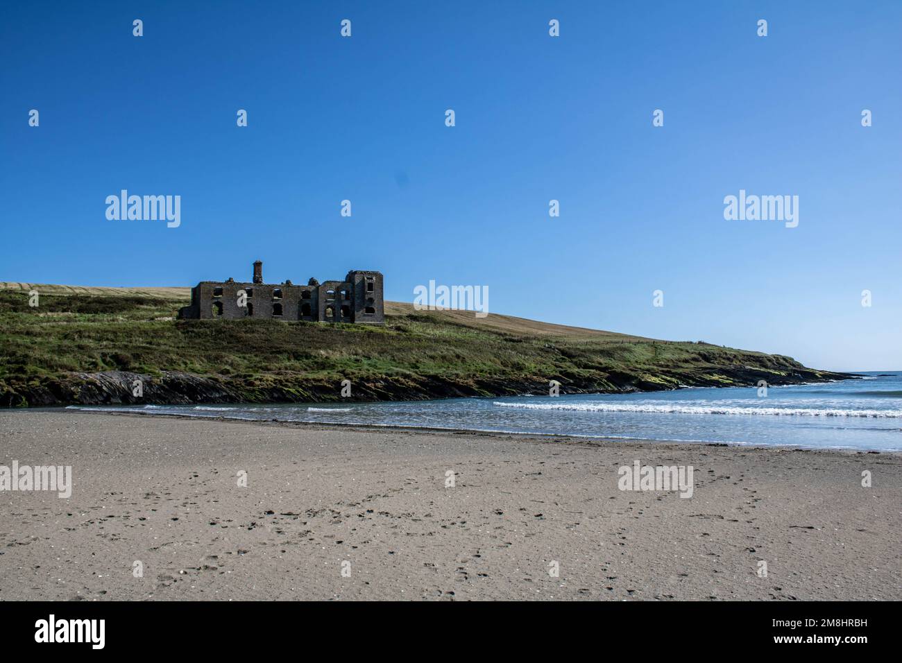 The ruins of Howe Strand Coast Guard Station in front of the blue sea ...